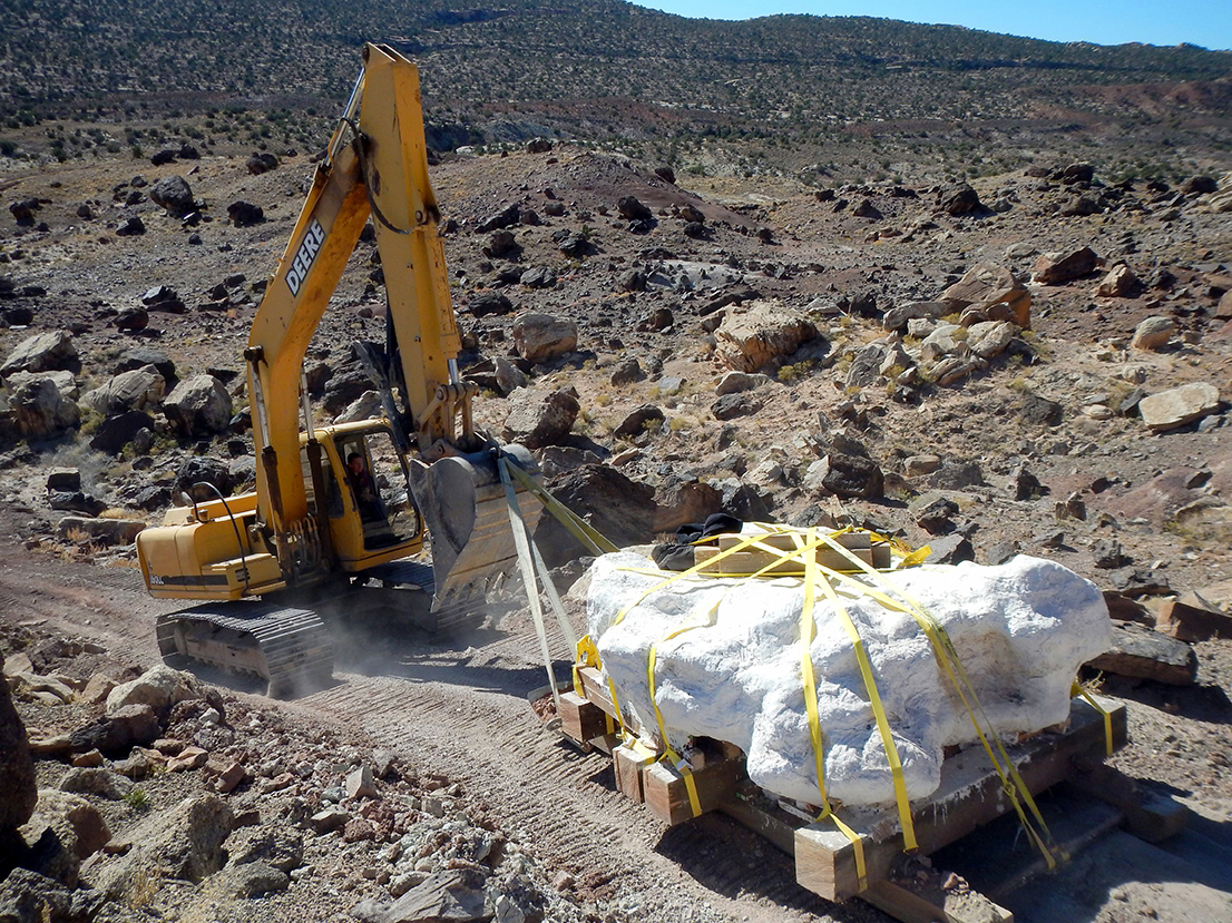 A trackhoe pulls the nine-ton field jacketed megablock containing ...